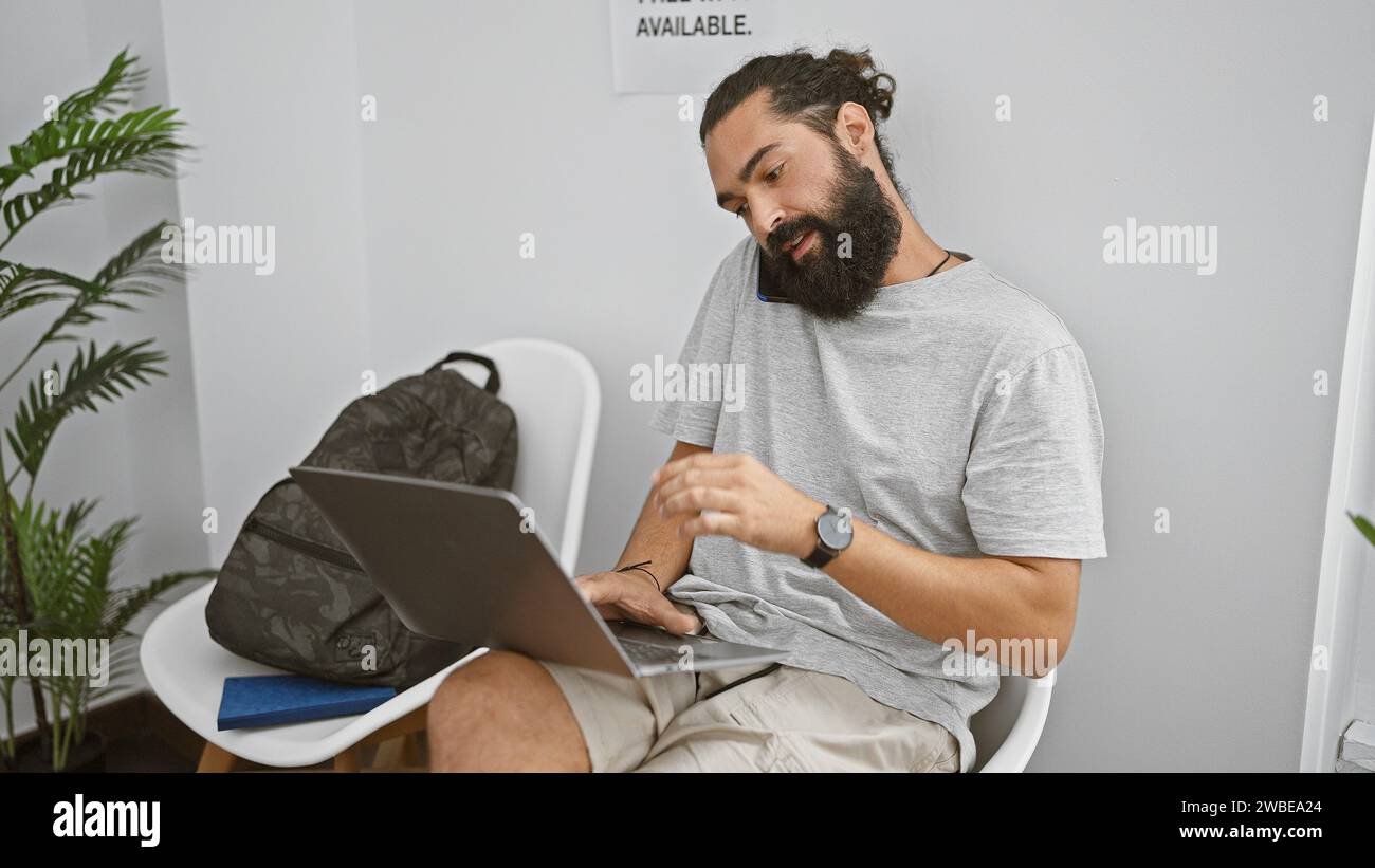 Bearded young hispanic man using laptop in a modern indoor room ...
