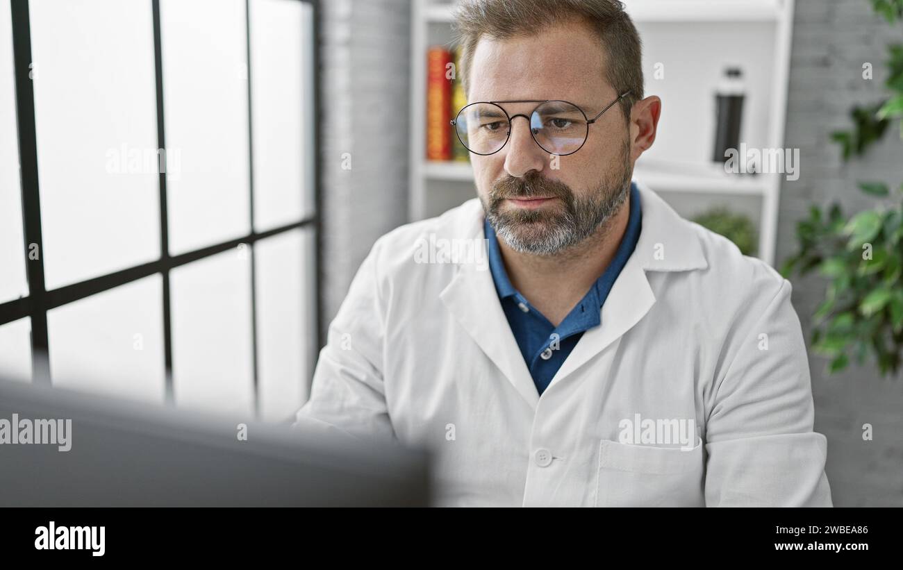 Hispanic mature man with grey hair in lab coat working indoors at ...