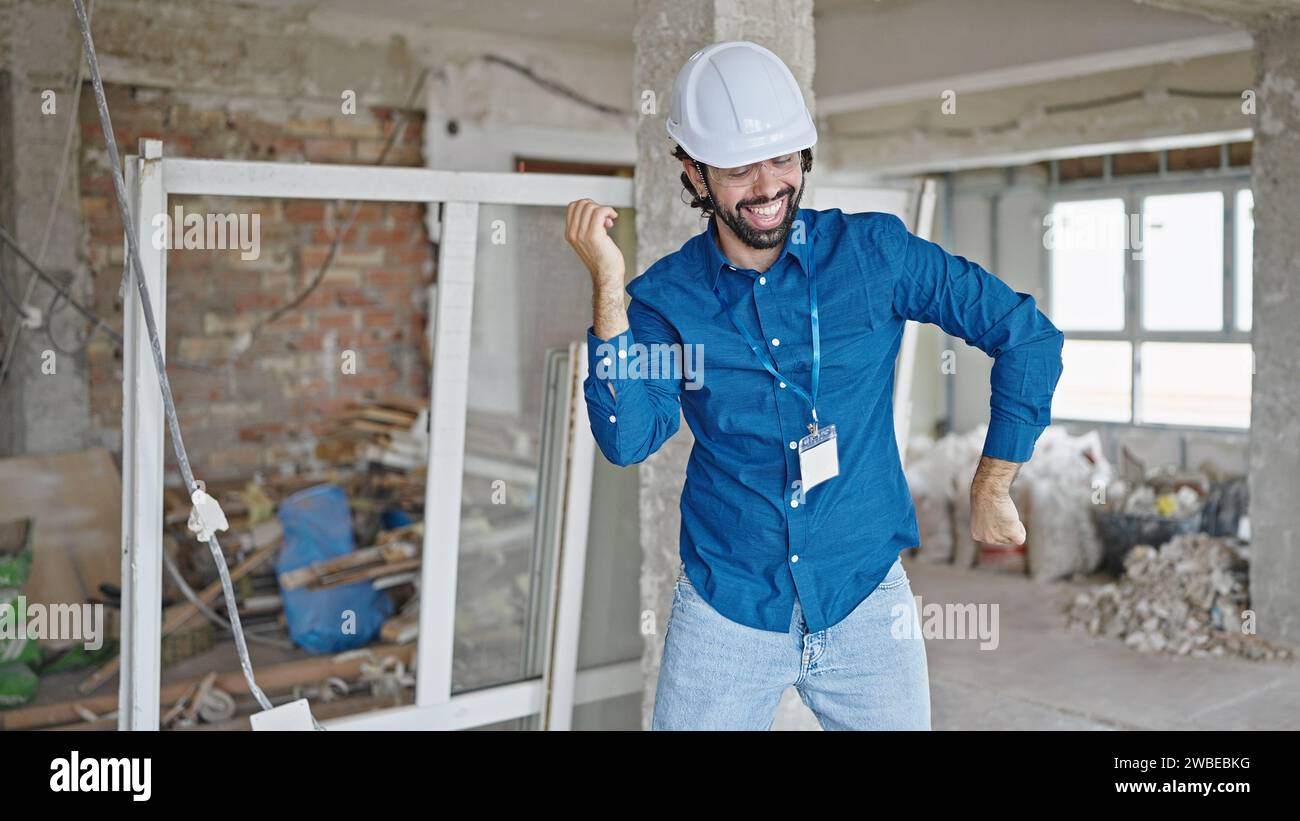 Young hispanic man architect smiling confident dancing at construction ...