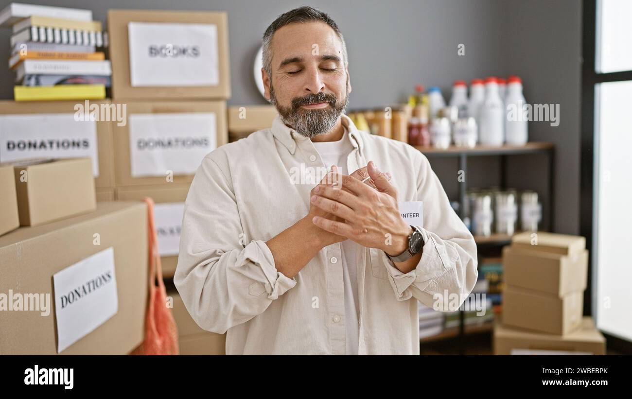 A content man with grey beard smiling and eyes closed stands amongst ...
