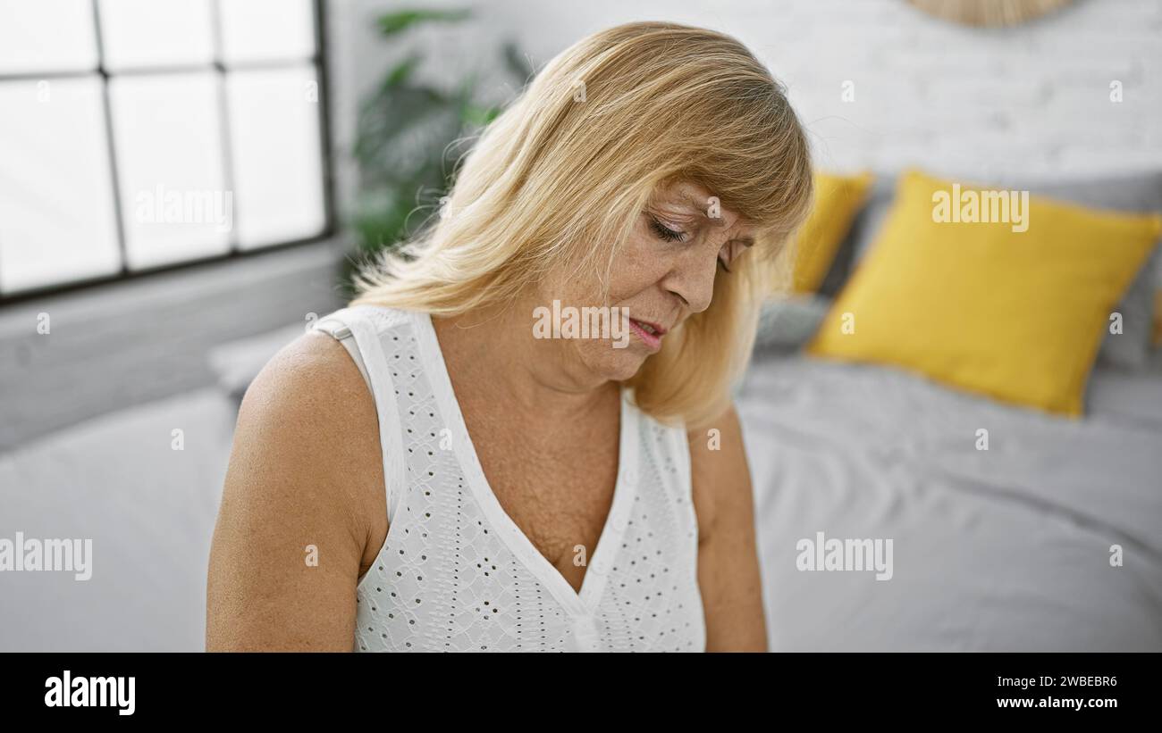 In her cozy home, a serious-faced middle age blonde woman finds comfort ...