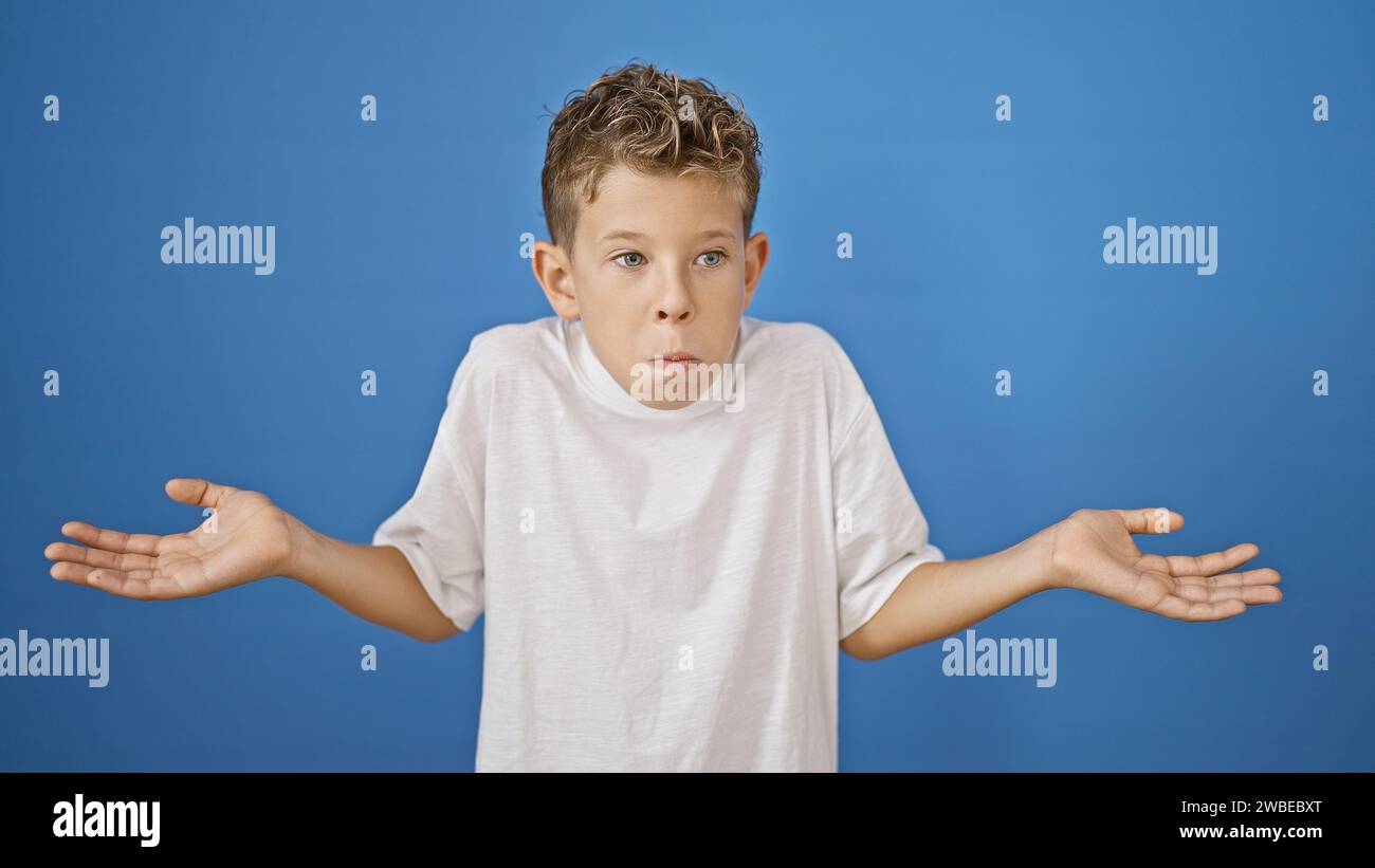 Clueless blond boy, with adorable expression, standing uncertain on ...