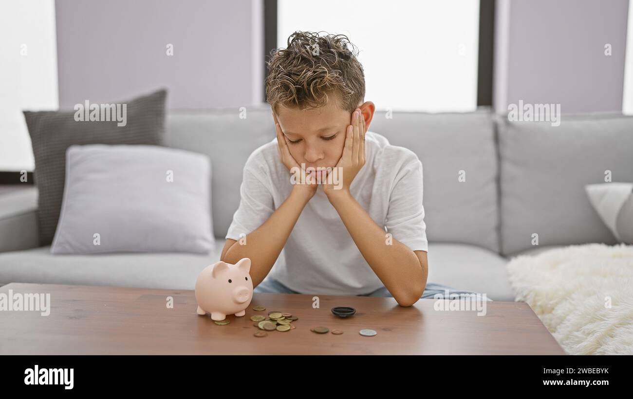 Adorable blond boy, sitting solemn and sad at home, sceptically ...