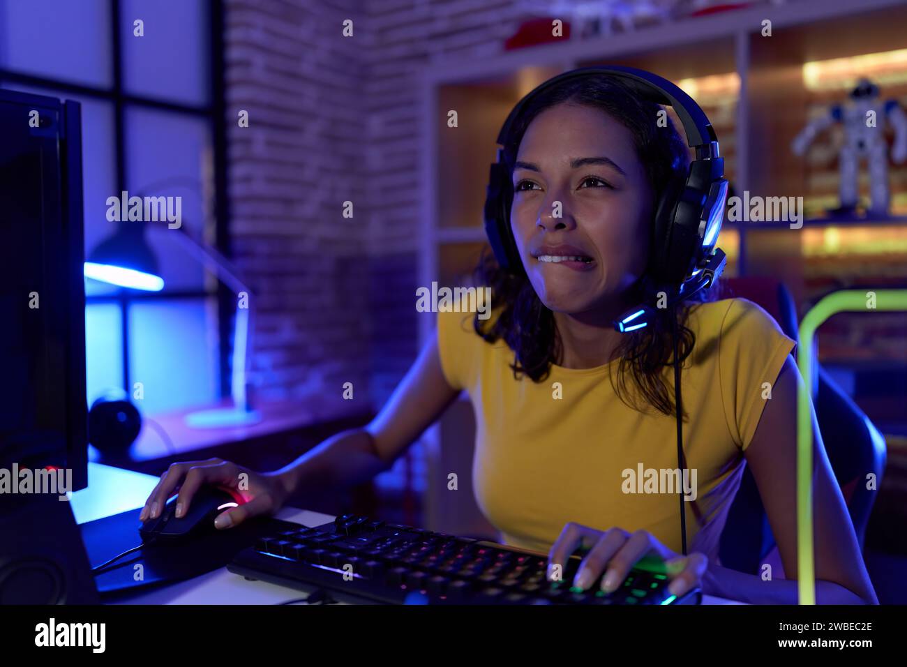 Young african american woman streamer playing video game using computer ...