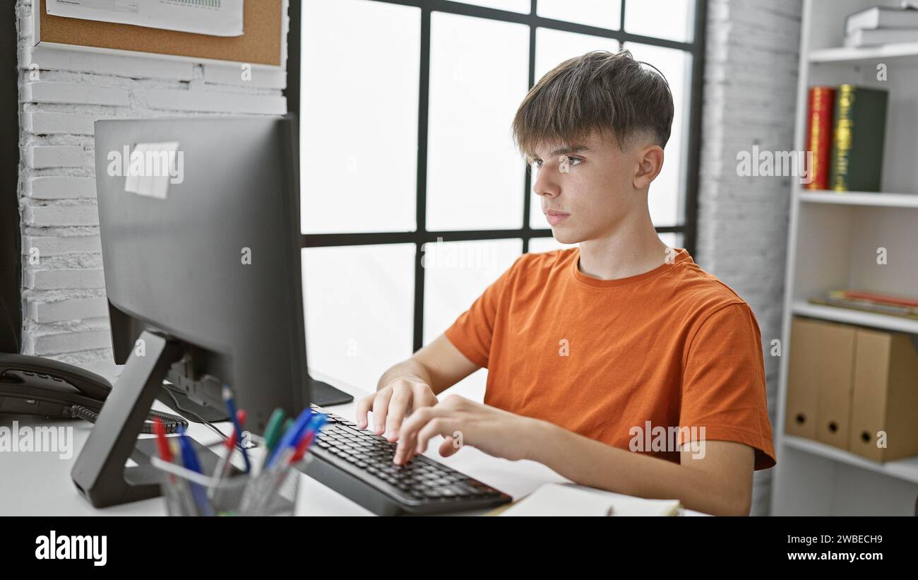 Caucasian teen boy studying on computer at library table, evoking ...