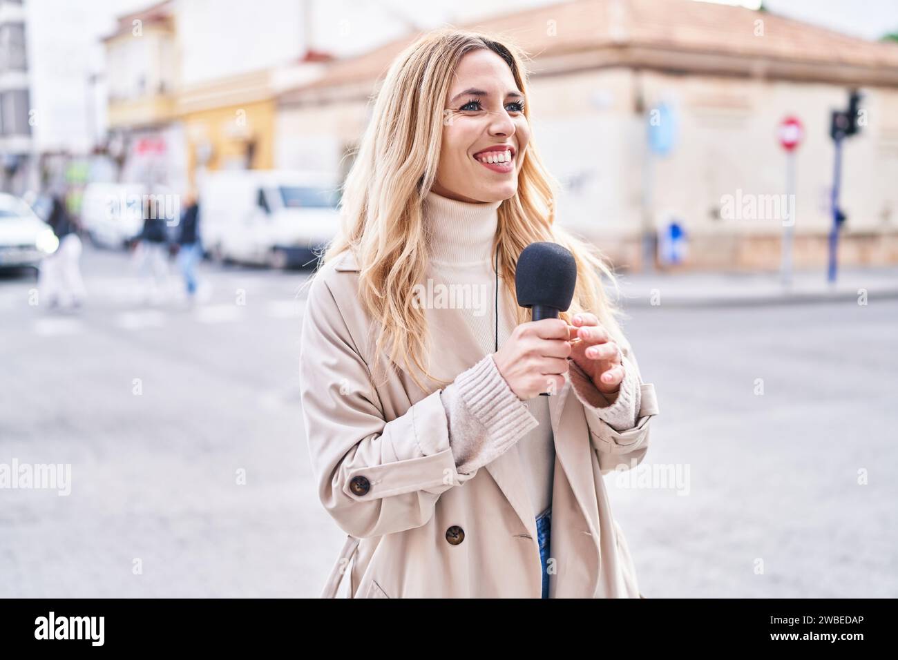 Young blonde woman reporter working using microphone at street Stock ...