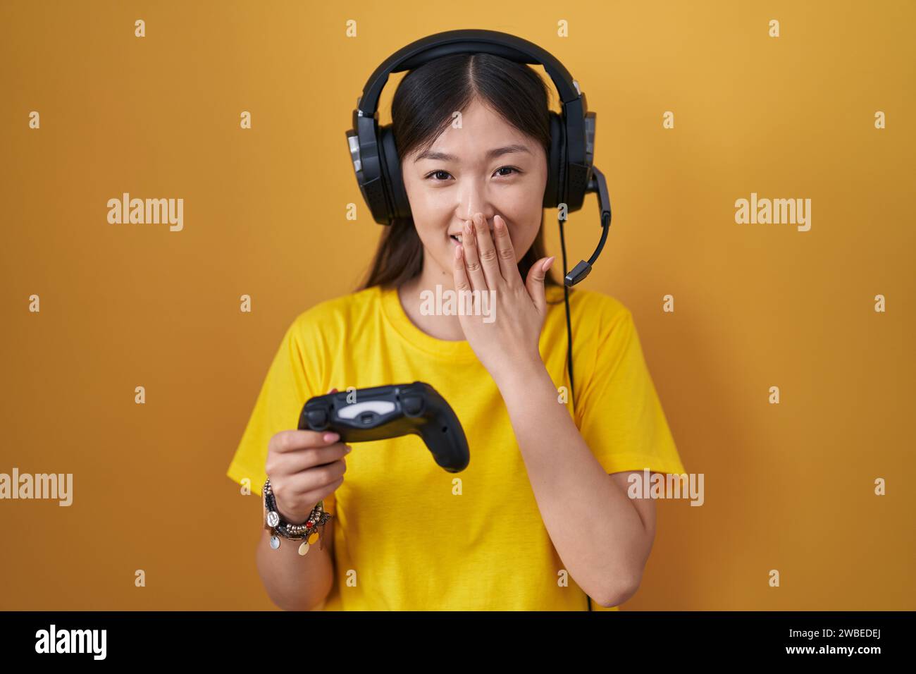 Chinese young woman playing video game holding controller laughing and ...