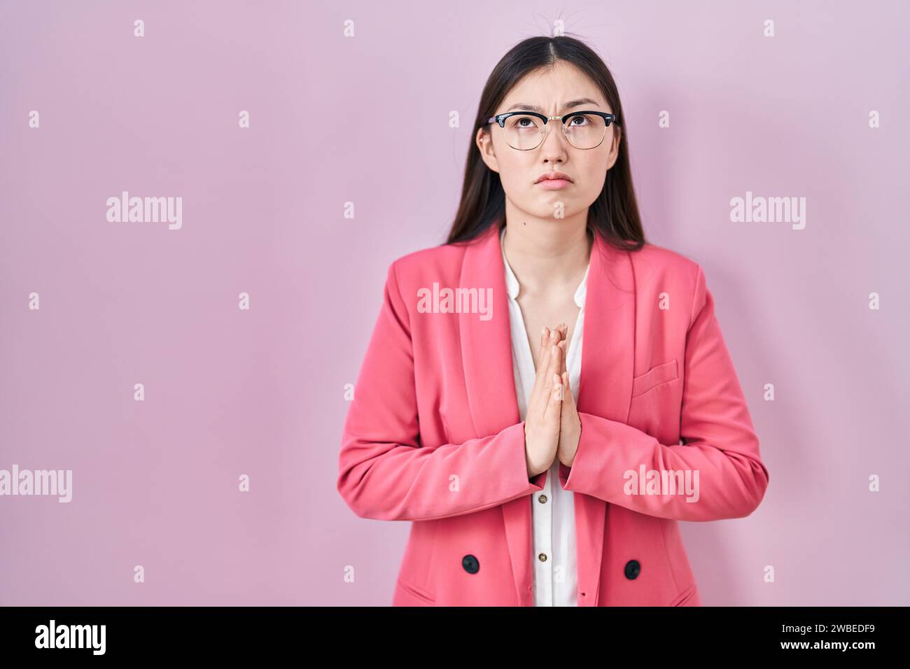 Chinese business young woman wearing glasses begging and praying with ...