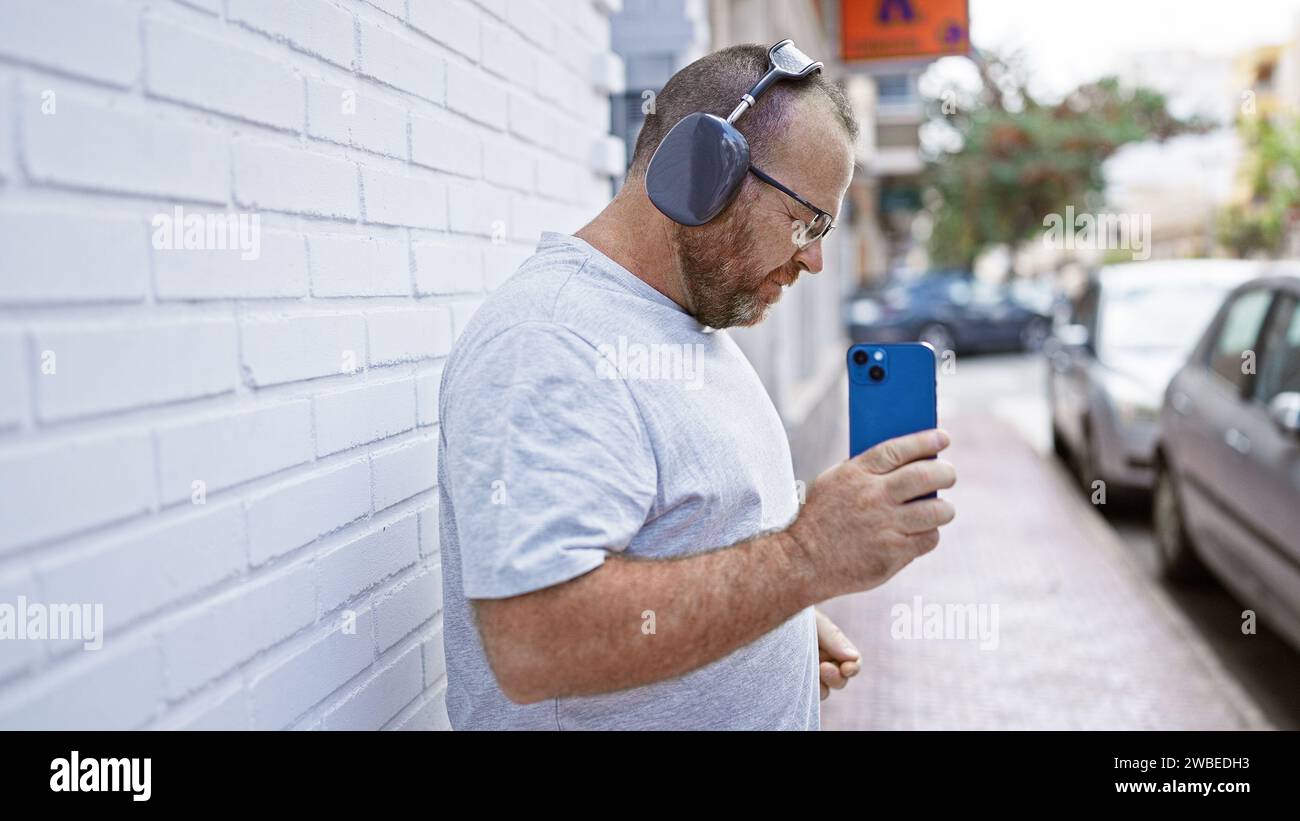 Cheerful, middle-aged, bearded caucasian man, vibing on urban street ...
