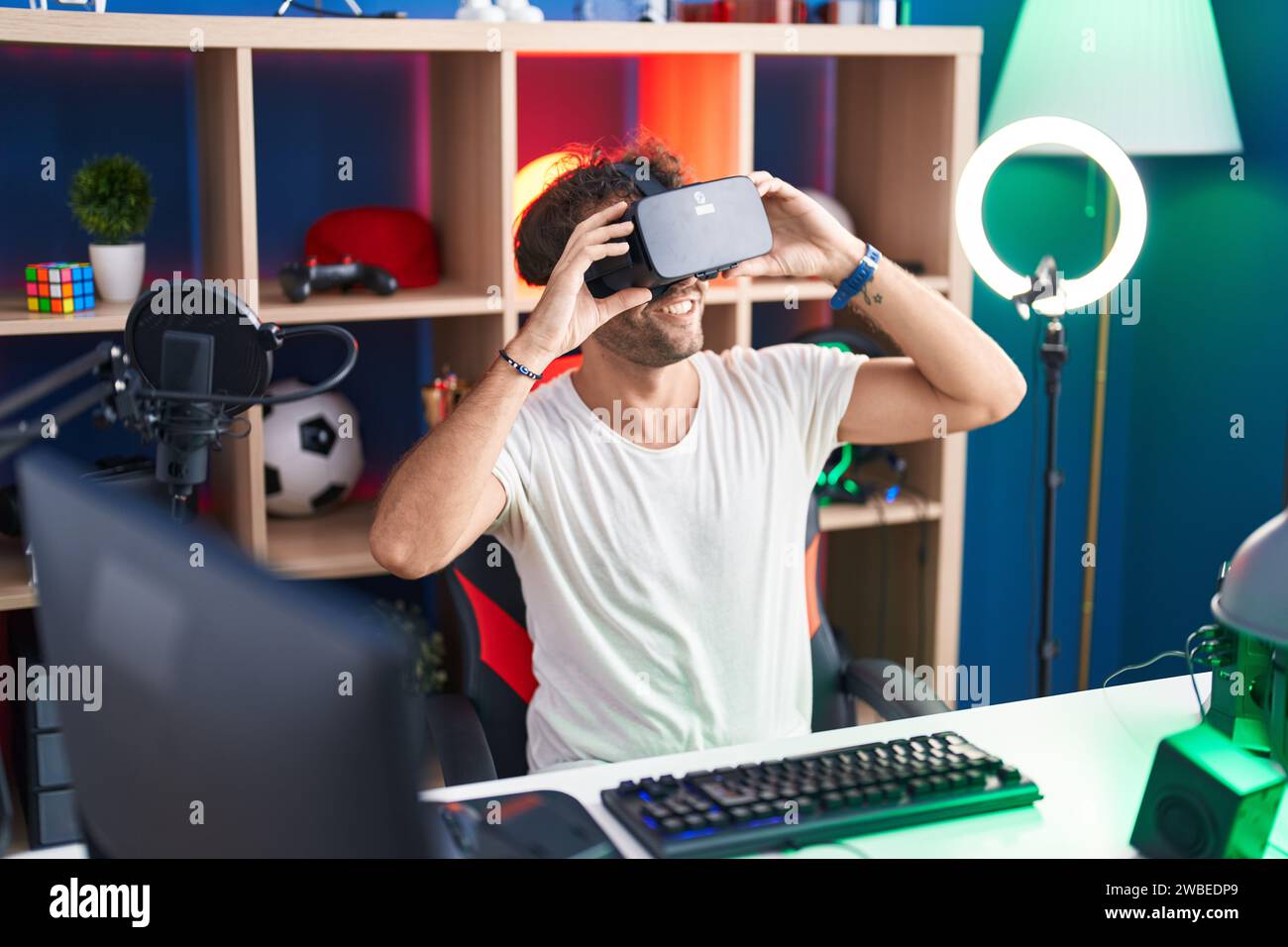 Young hispanic man streamer playing video game using virtual reality ...