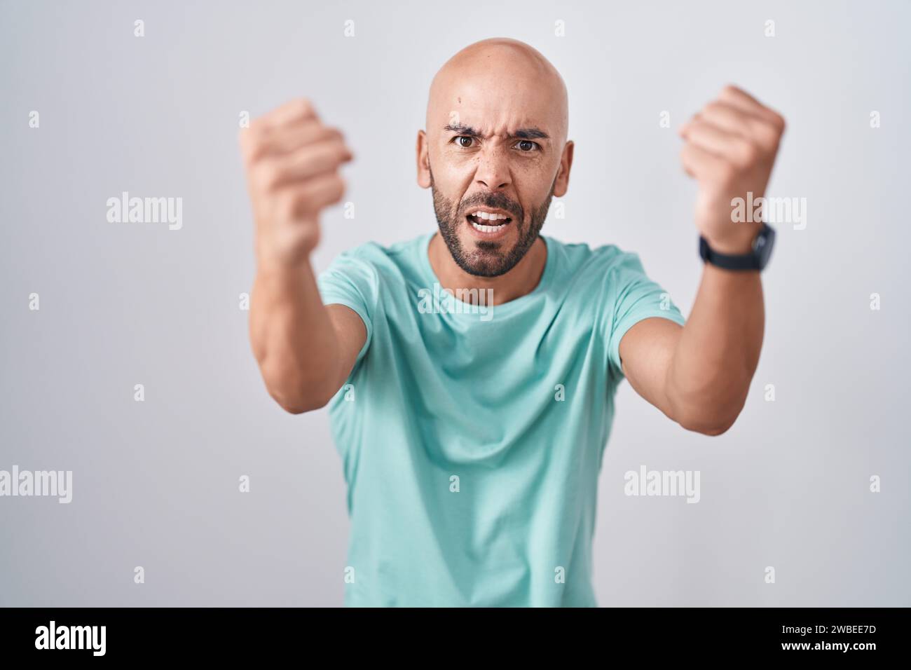 Middle age bald man standing over white background angry and mad ...