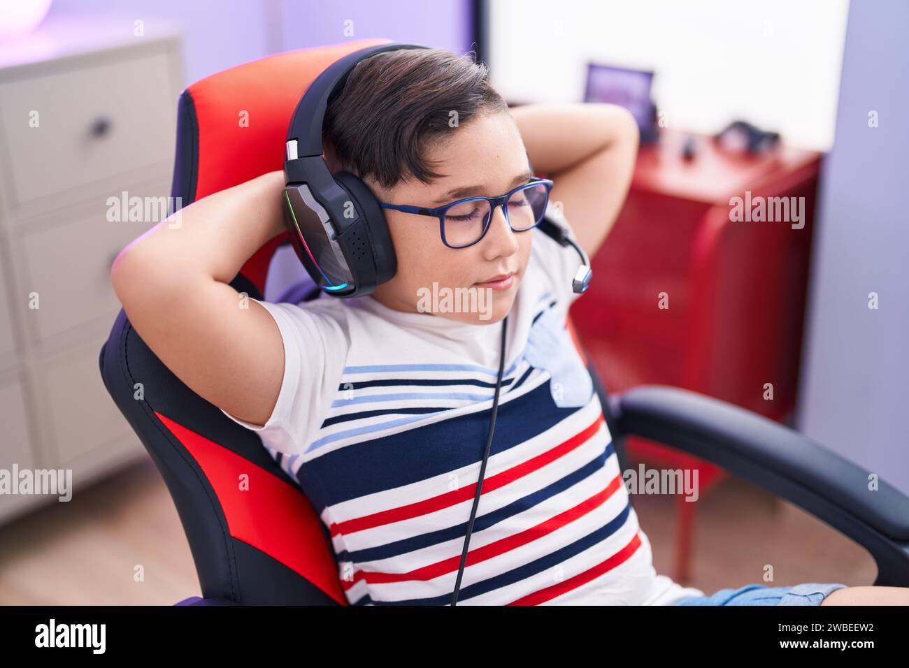 Adorable hispanic boy streamer relaxed with hands on head at gaming ...