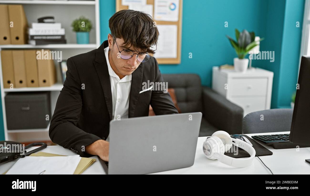 Serious, young hispanic teenager embracing technology, working as a ...