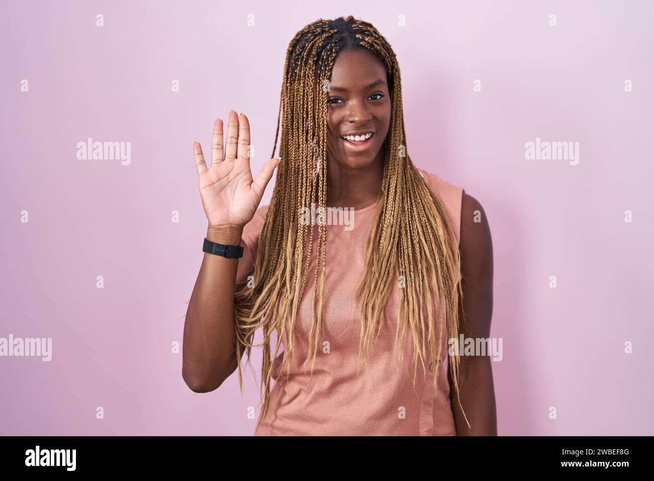 African american woman with braided hair standing over pink background ...