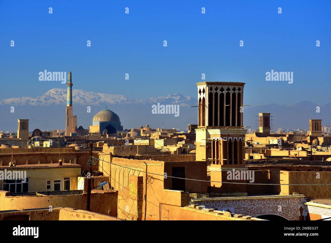 Roof top city view of Yazd old city, Iran with snow capped mountains ...