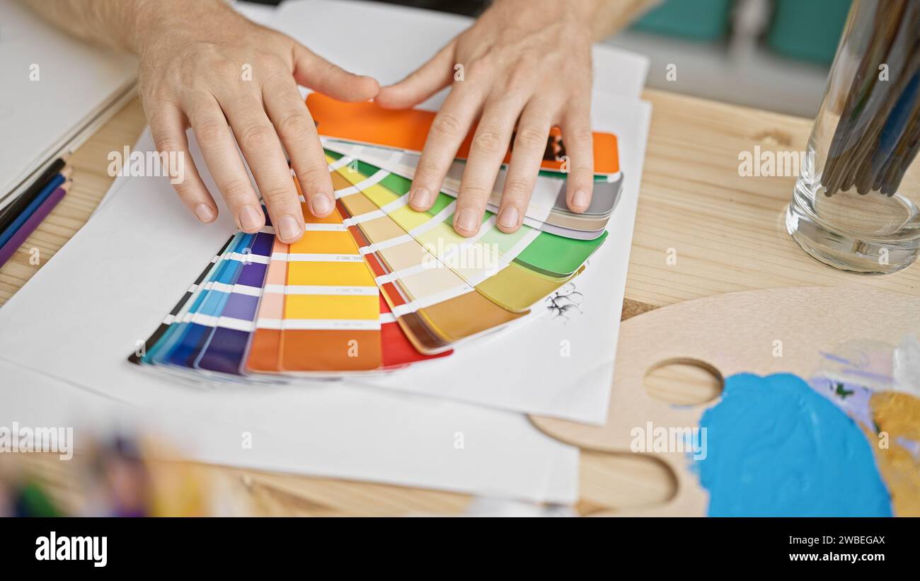A close-up of hands selecting a color swatch from a palette, indicative ...