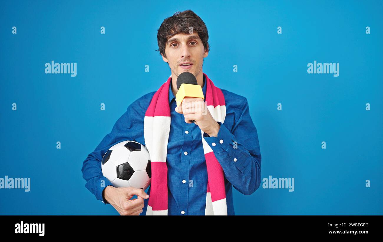 Young hispanic man soccer reporter working using microphone holding ...