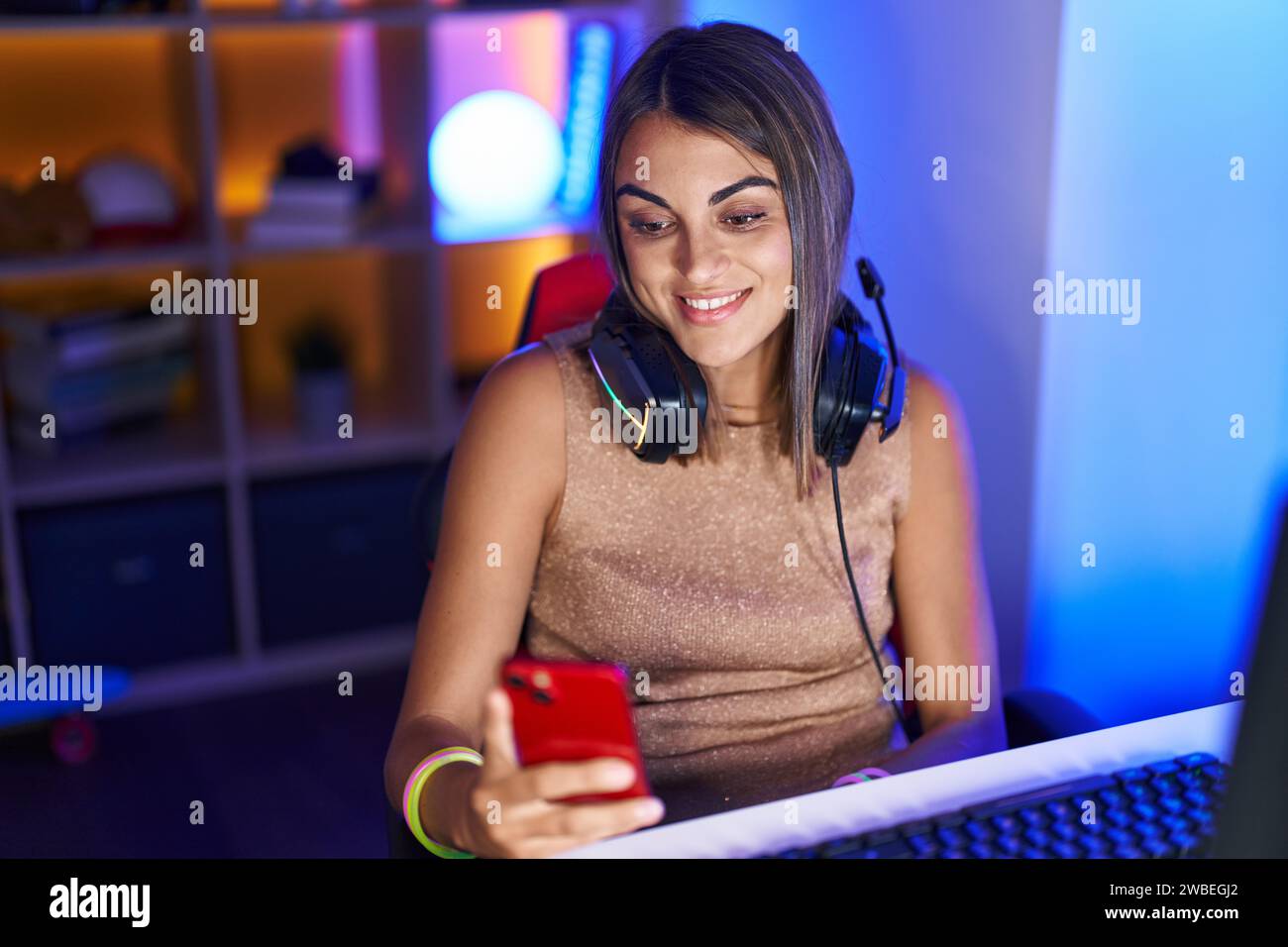 Young beautiful hispanic woman streamer using computer and smartphone ...