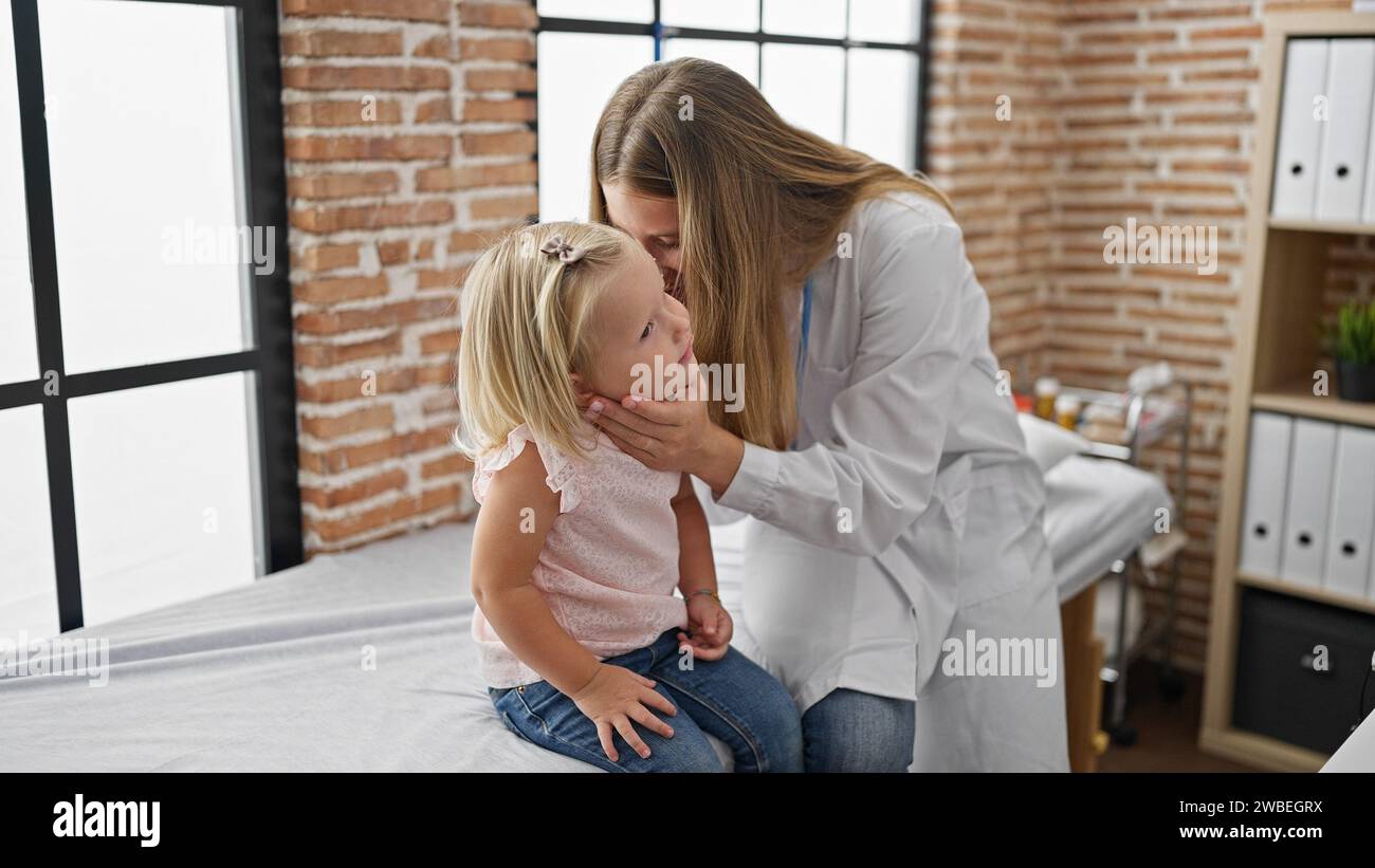 Pediatrician doctor at clinic examining ear, serious expression as ...