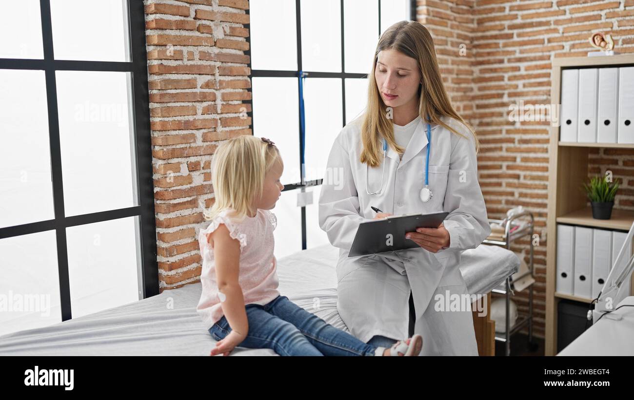 Cute child patient and caring pediatric doctor together, sitting in ...
