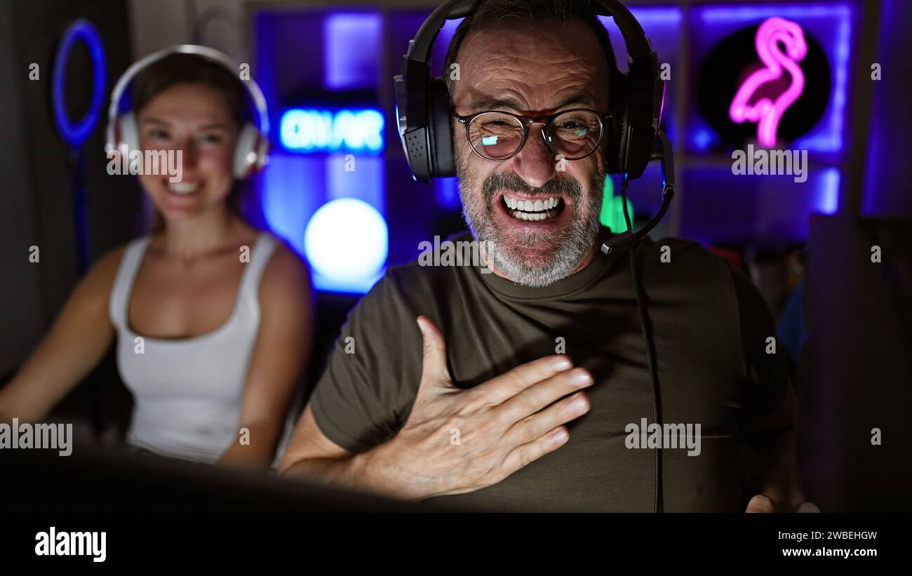 Exciting night in gaming room, two cheerful gamers, father and daughter ...