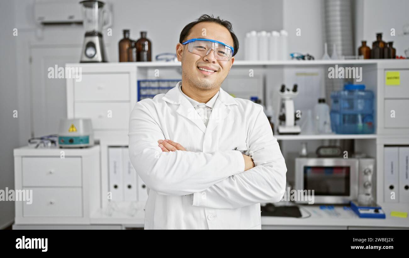 Smiling, confident young chinese man, a pro in science, at his lab ...