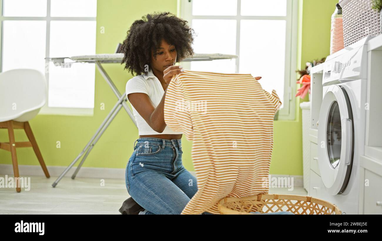 African american woman washing clothes at laundry room Stock Photo - Alamy