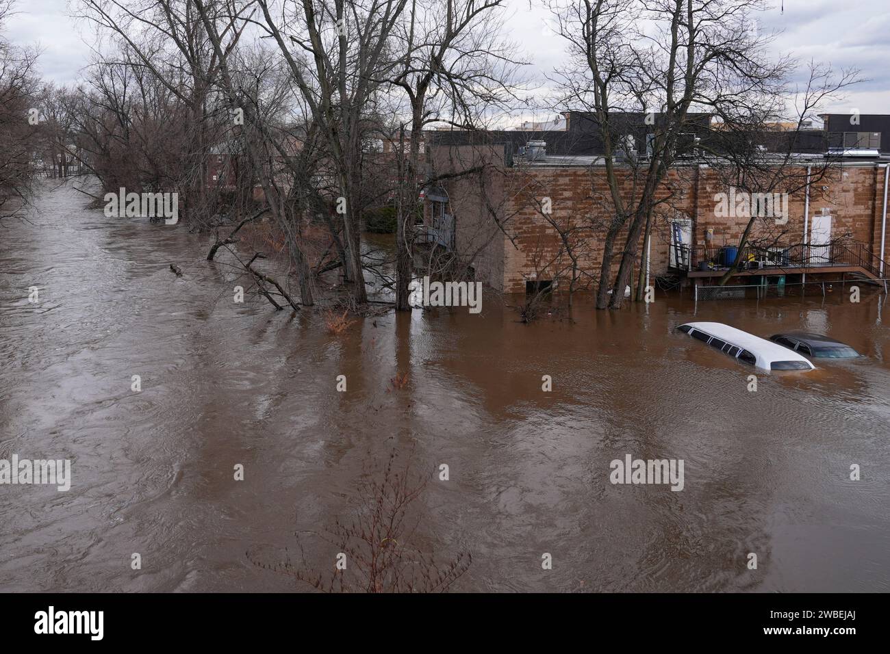 The Saddle River, left, overflowed its banks, submerging some cars, in ...
