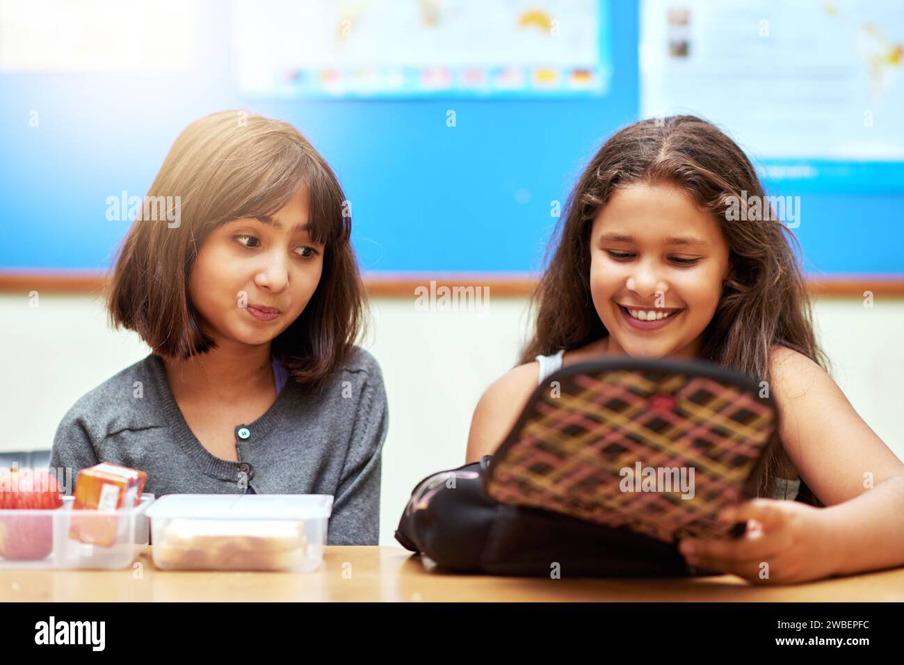 Happy children, students and eating lunch in classroom at school for ...
