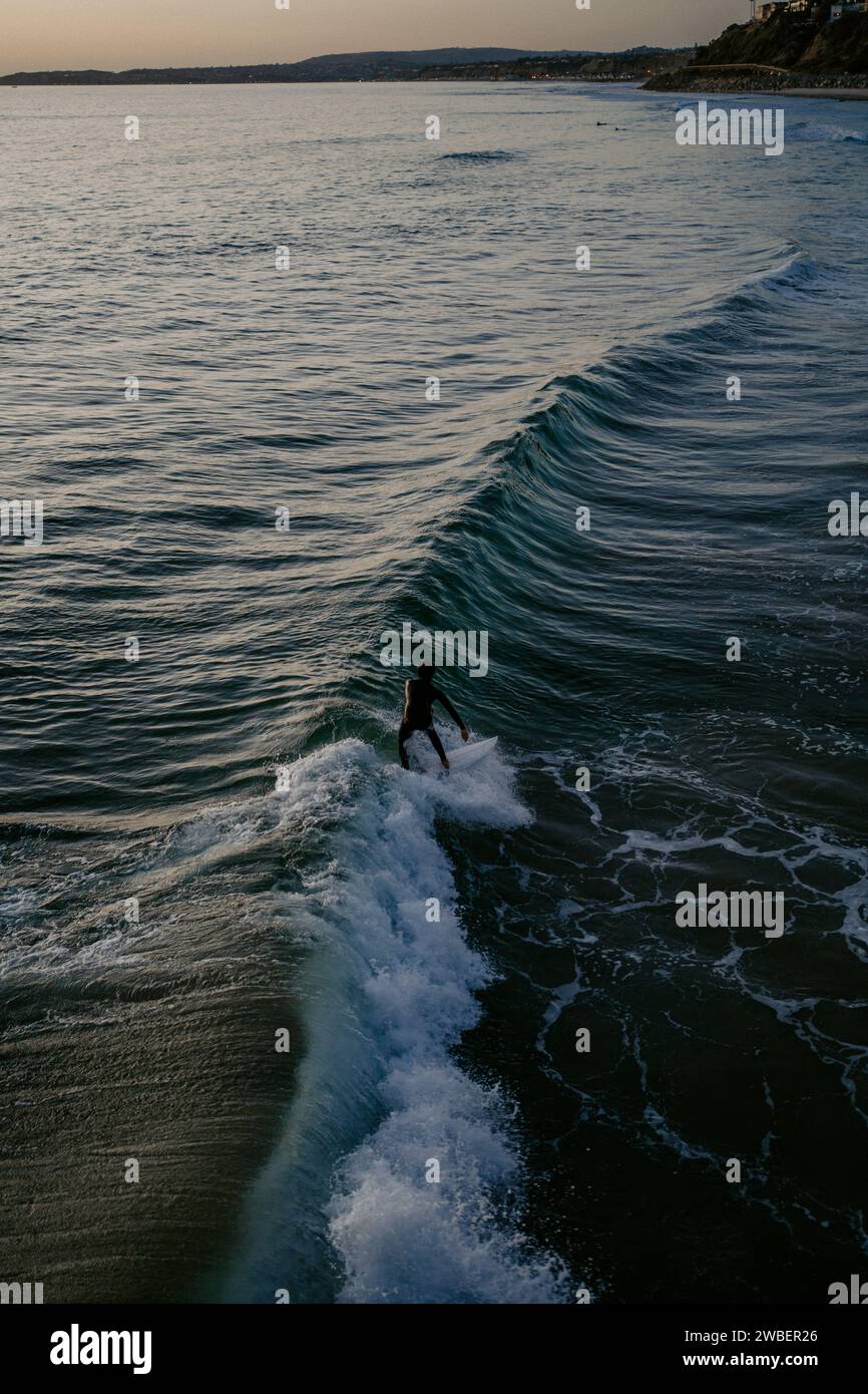 Surfing during Sunset Stock Photo - Alamy