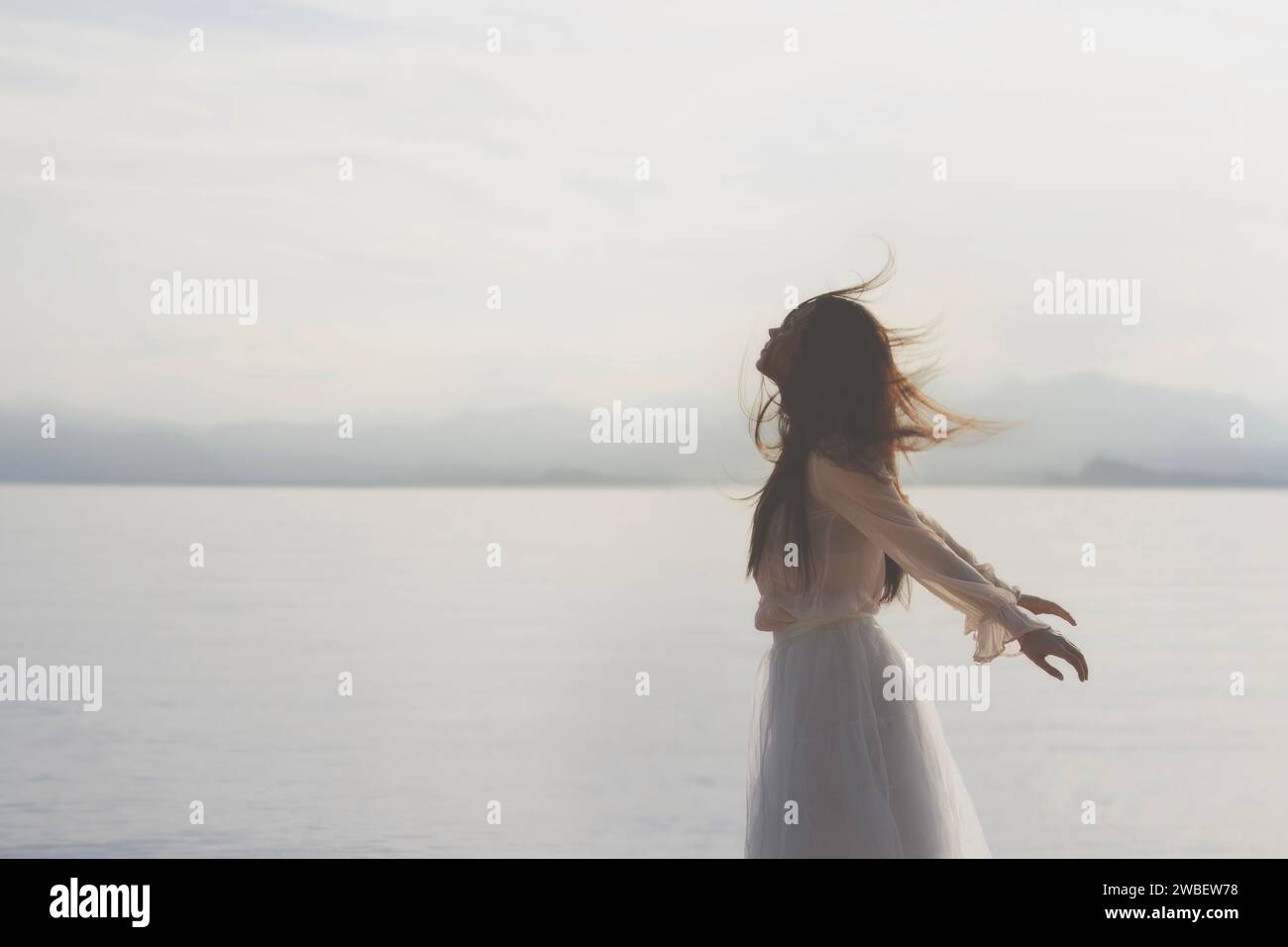 vital young woman with her hair blowing in the wind in front of the ...