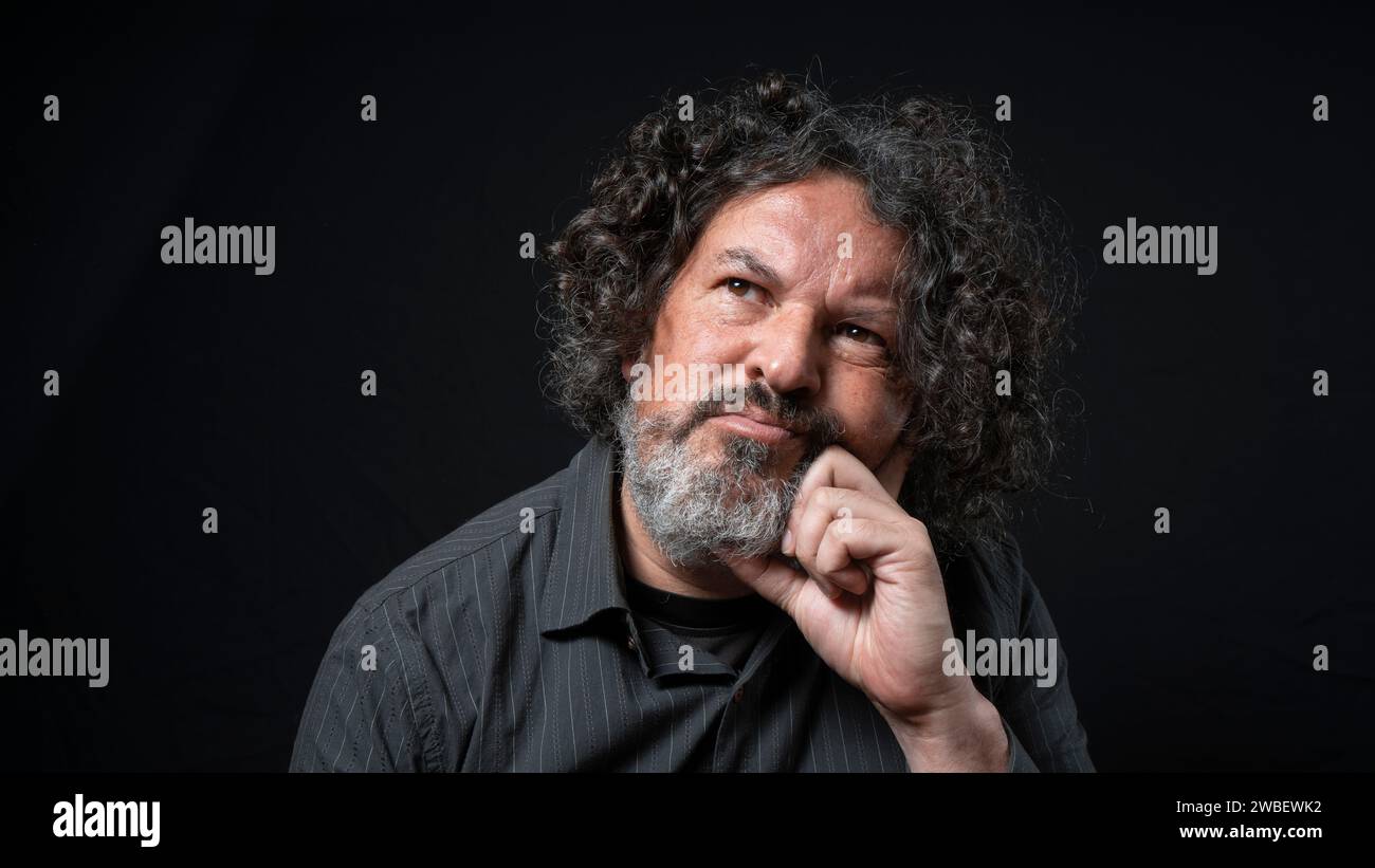 Portrait of latin man with white beard and black curly hair with ...