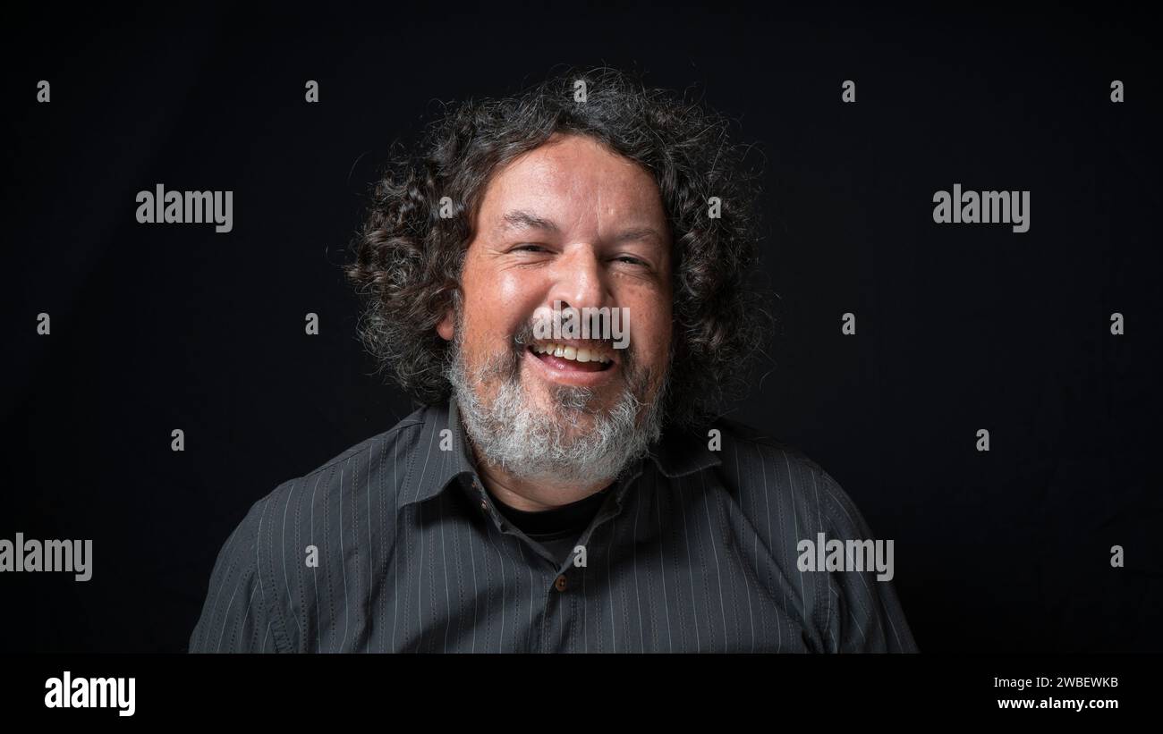 Portrait of latin man with white beard and black curly hair with happy ...
