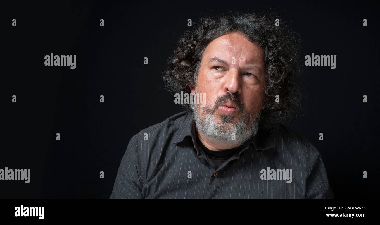 Portrait of latin man with white beard and black curly hair with ...