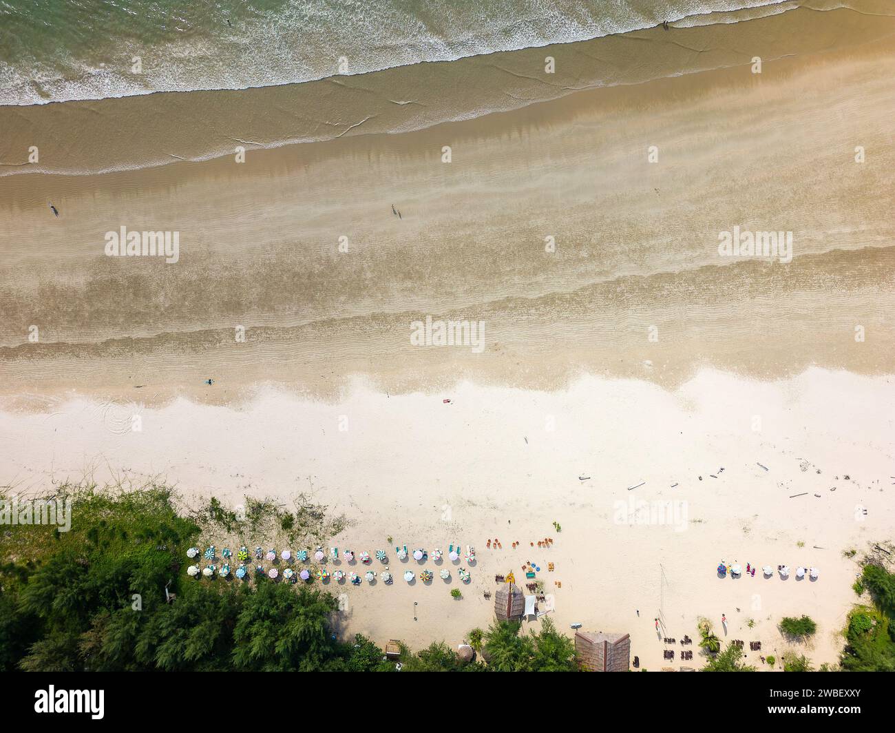 Top down aerial view of a small beach bar and umbrellas on a large ...