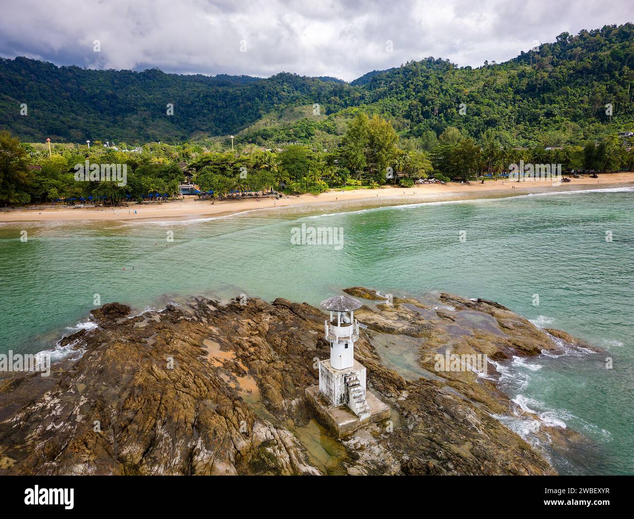 Aerial view of a small lighthouse located on a rock offshore from a ...