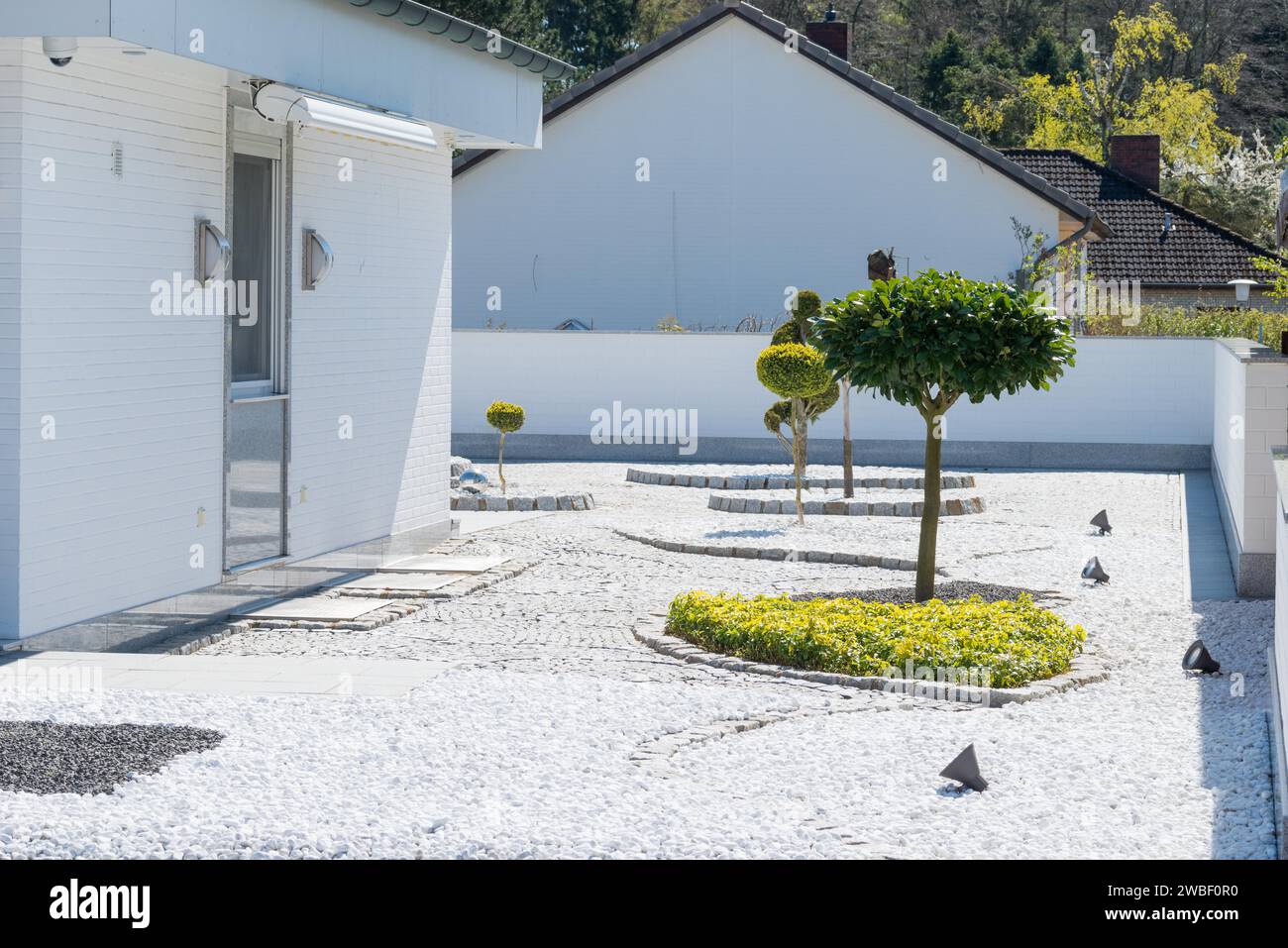 Modern garden with geometric shapes and spotlights next to a white ...