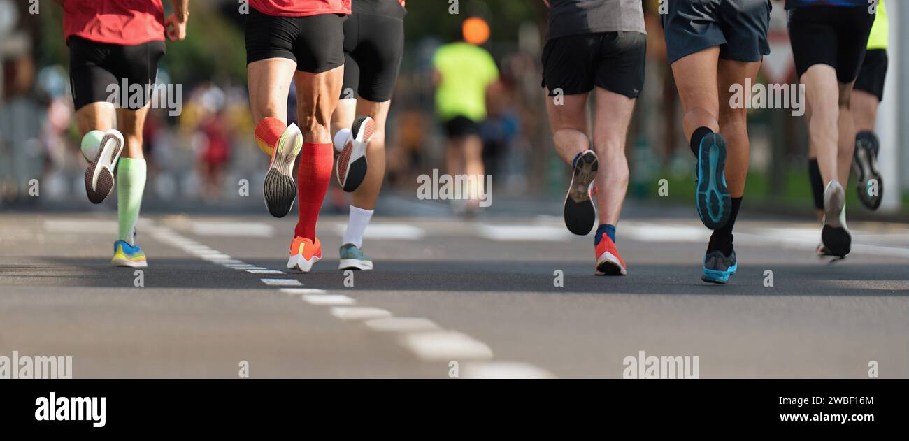 Marathon runners running on city road, large group of runners, close-up ...