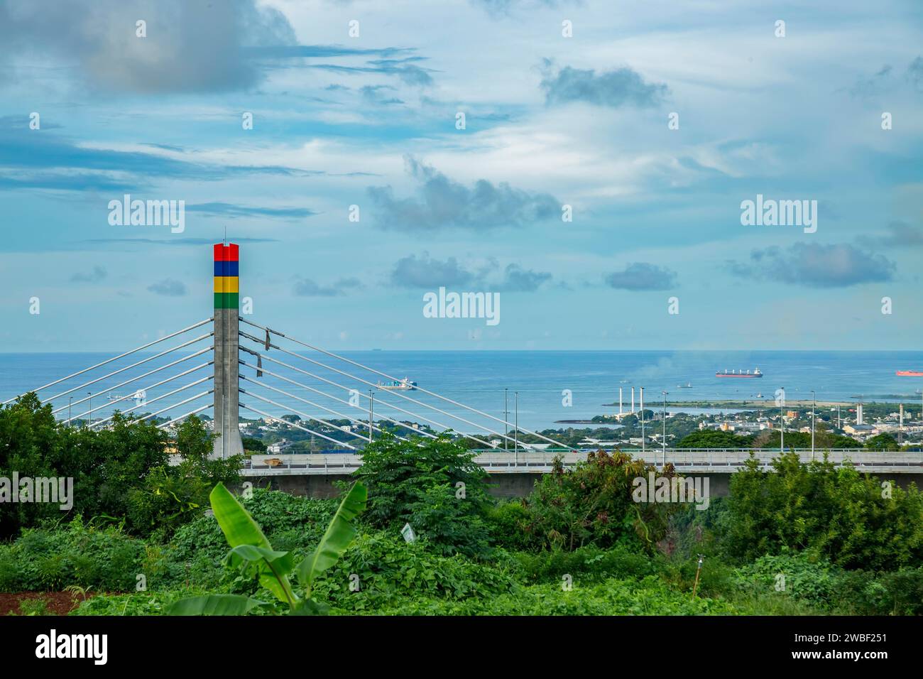 A highway with Mauritian emblem on pillar and a truck driving ...