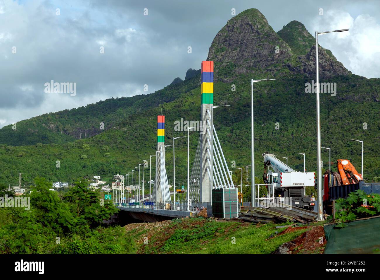 A highway with Mauritian emblem on pillar and a truck driving ...
