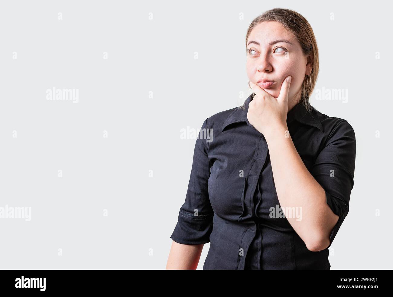 Young woman thinking with hand on chin isolated. Thoughtful beautiful ...