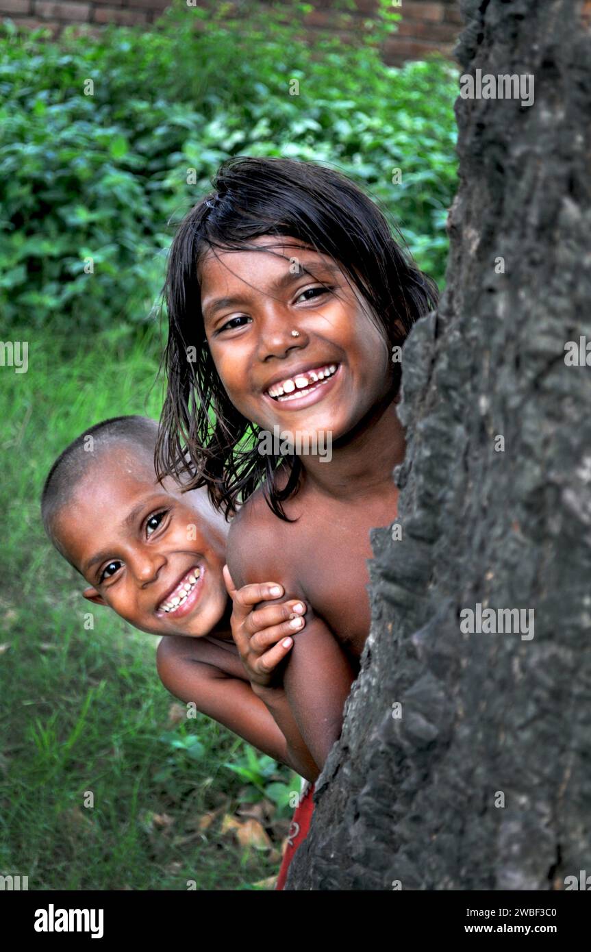 Portrait of two children playing hide and seek in the slums of Rayer ...