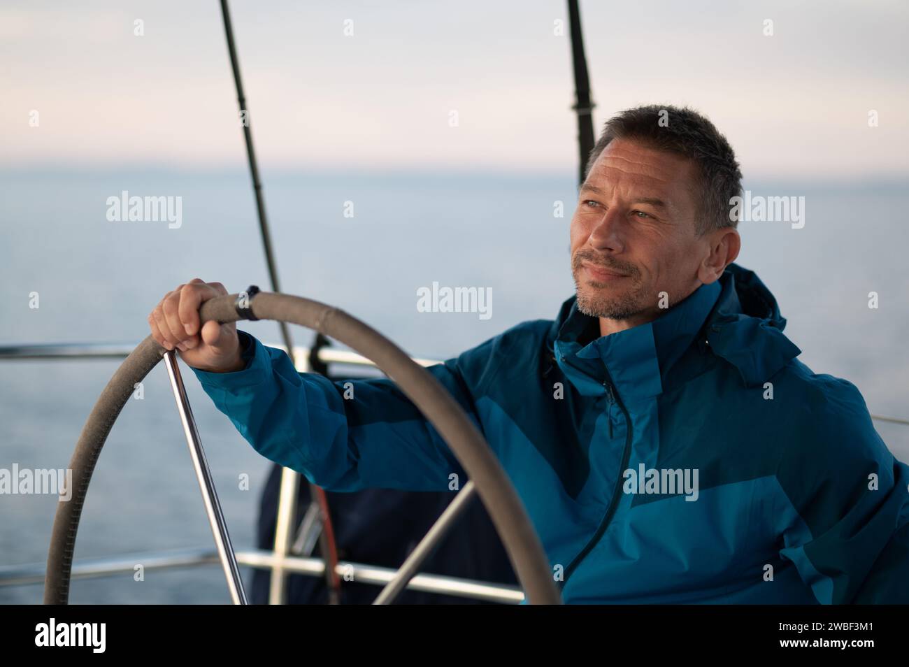 Good-looking mature man sailing a yacht and looking confident Stock ...