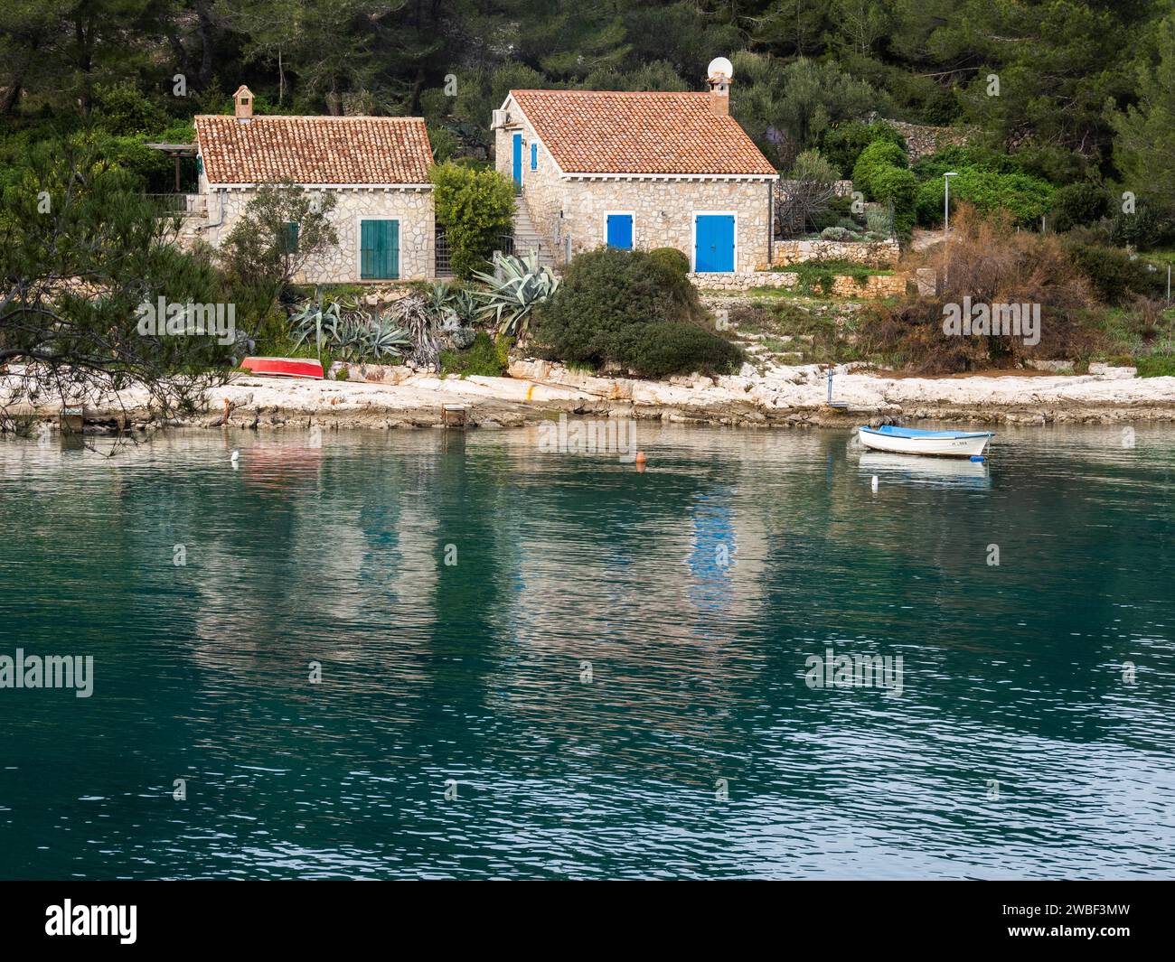View from the promenade path to a small house by the sea, near Veli ...