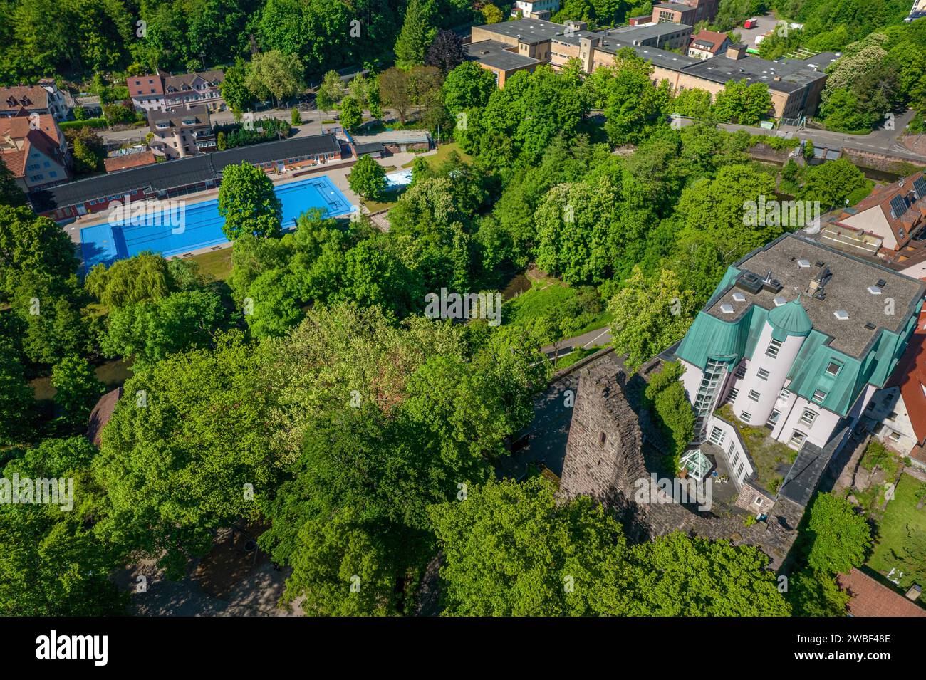 Bird's eye view of the swimming pool next to green trees and buildings ...