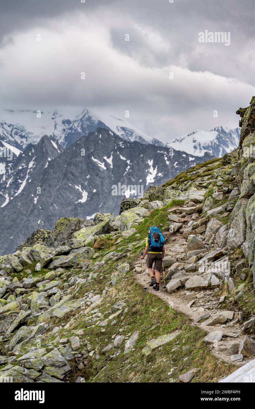 Two mountaineers on a hiking trail, view of glaciated rocky mountain peaks, Berliner Hoehenweg ...