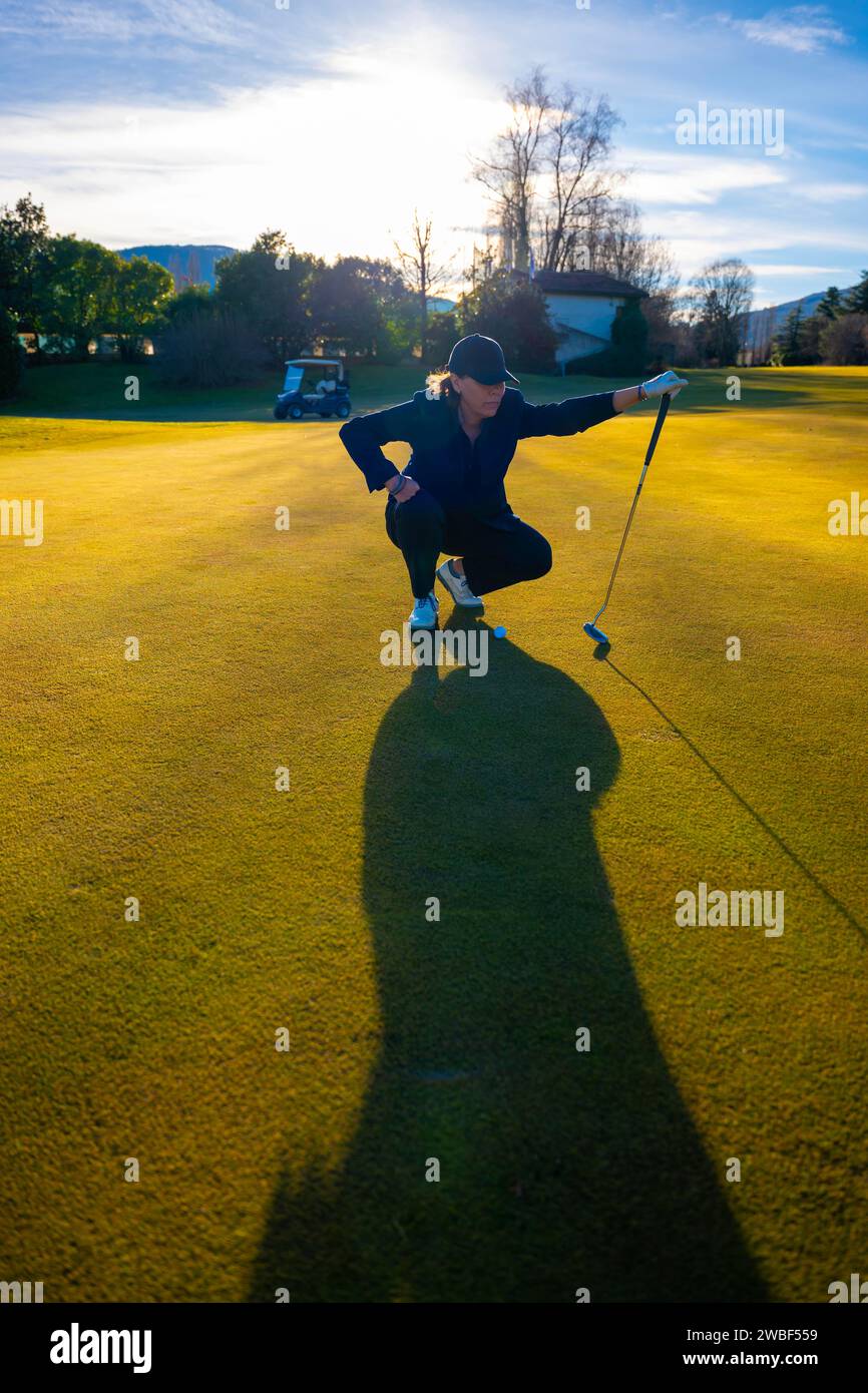 Female Golfer with Shadow on the Putting Green in Sunset with Lens ...