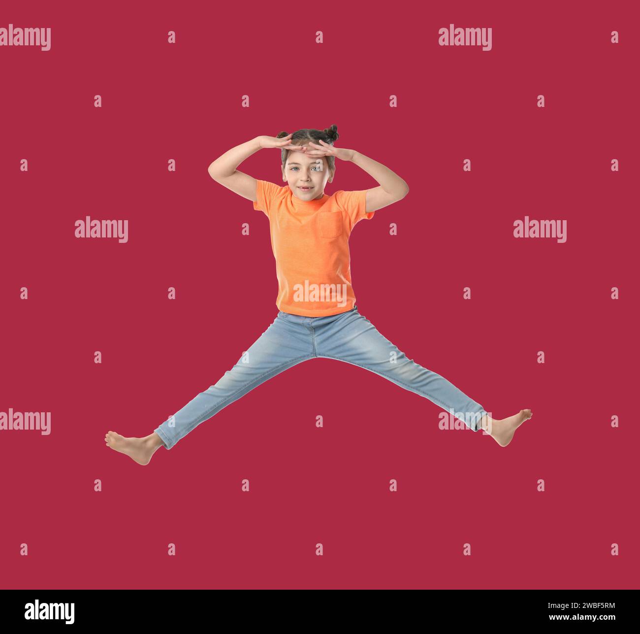 Happy cute girl jumping on red background Stock Photo - Alamy