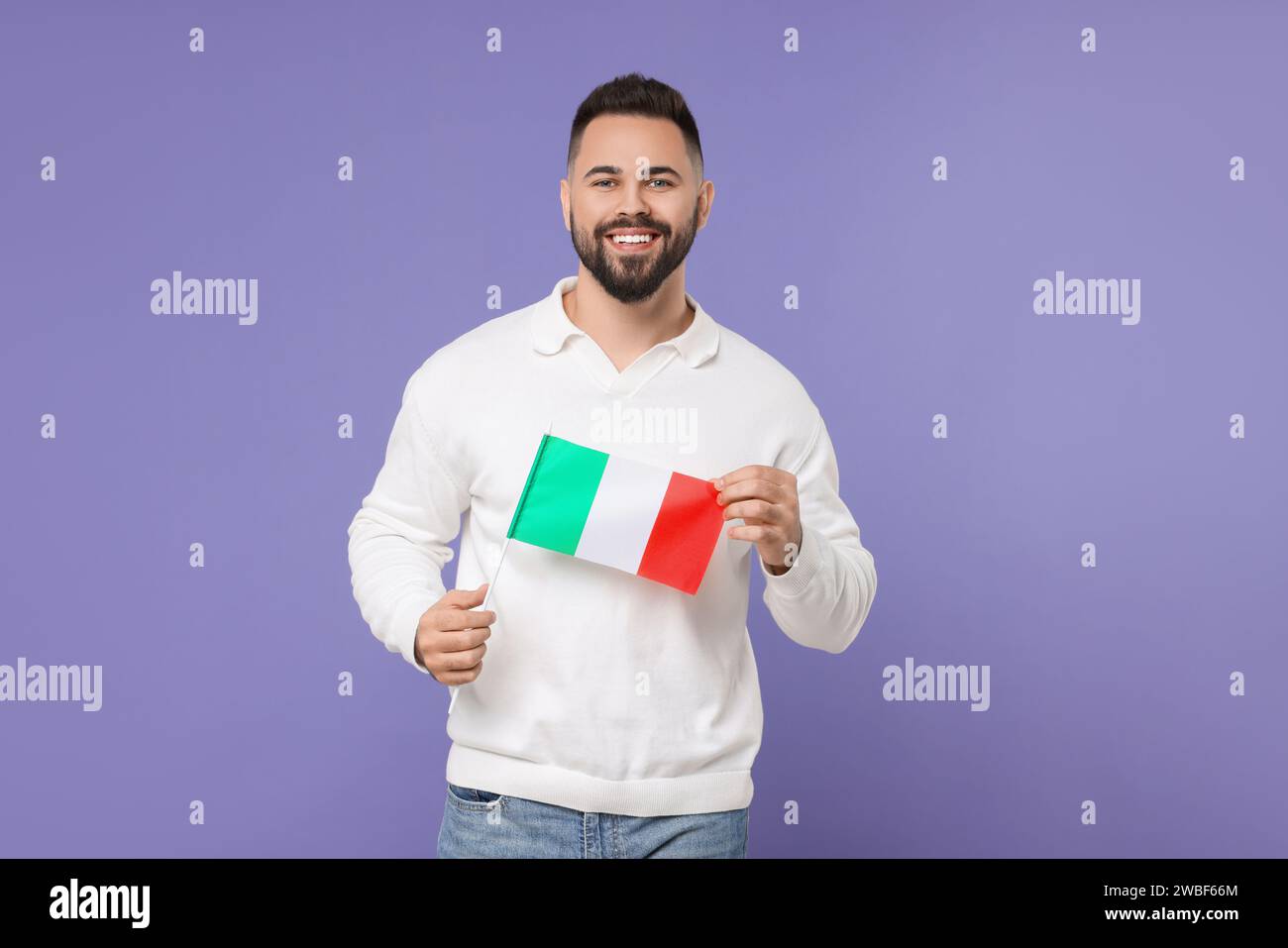 Young man holding flag of Italy on purple background Stock Photo - Alamy