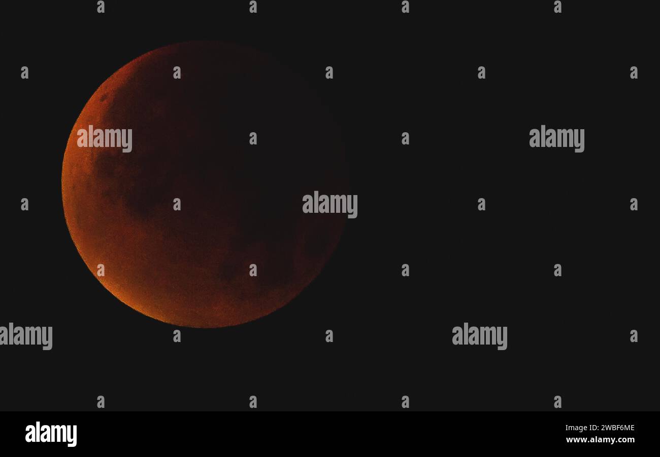 A reddish moon during a total lunar eclipse in the dark night sky, Haan ...